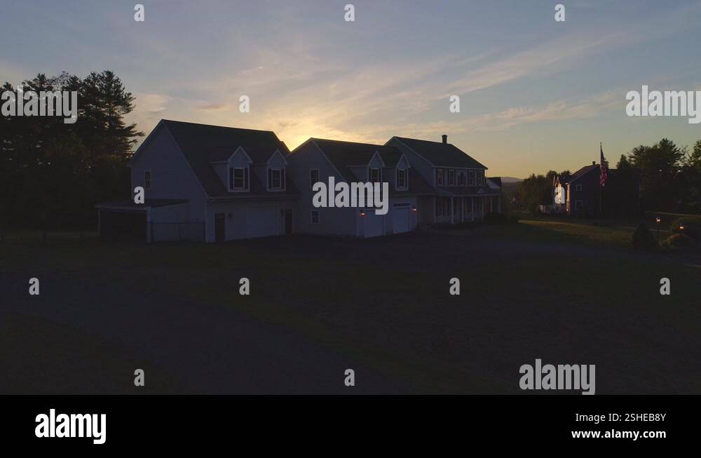 A sunset hiding behind a big house- drone video Stock Video Footage - Alamy