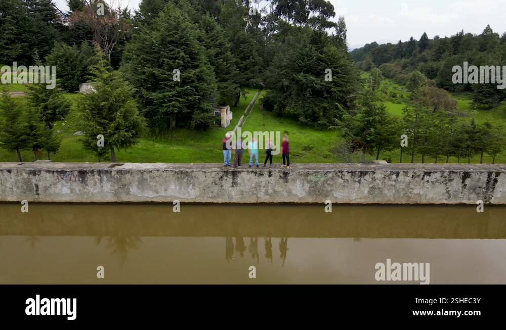 a few blur mans stands in front of scenic lake saying "Hello" in Mexico ...