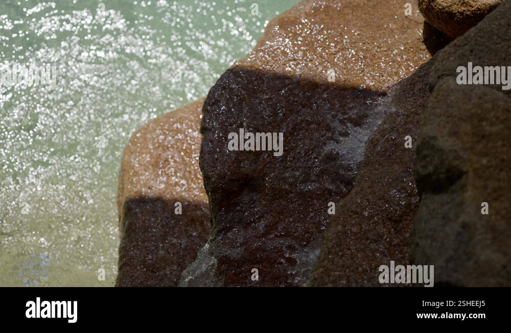 Running water into over rock into outdoor pool rock fountainClose up ...
