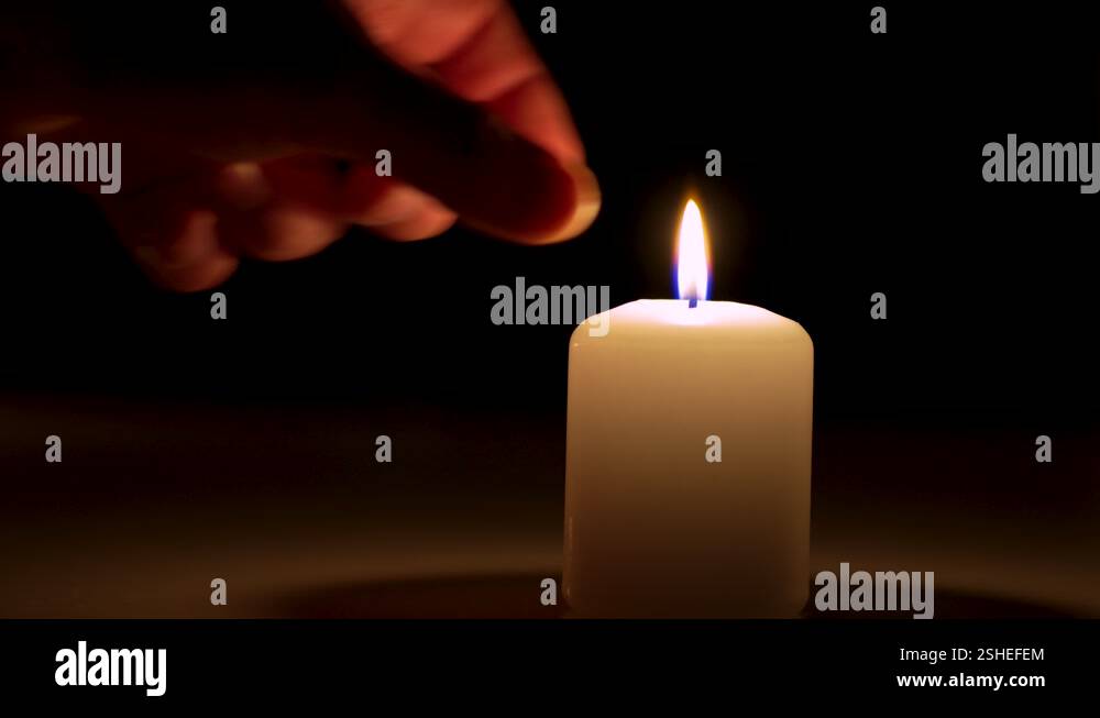 Fingers put out flame of candle Stock Video Footage - Alamy
