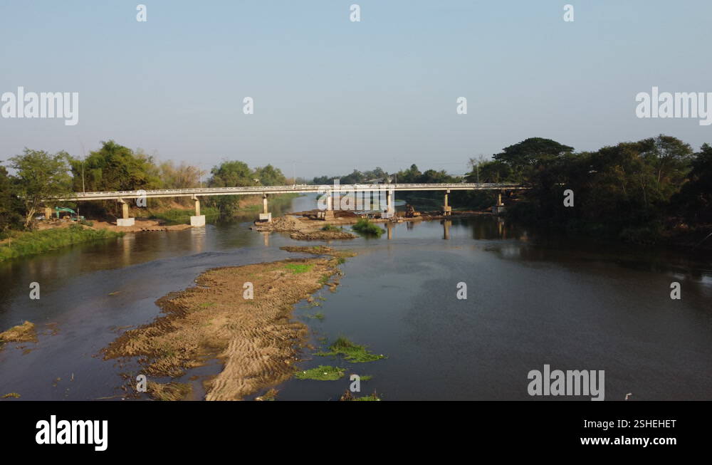 The bridge road over the river in the countryside with cars driving ...