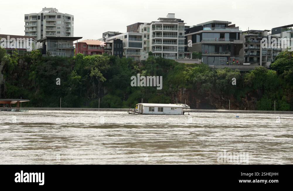 A floating home being carried away by flood waters in Brisbane during ...