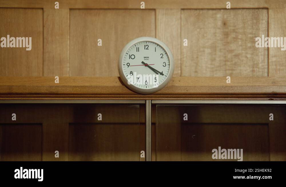 Clock hanging on the wall of a UK court room Stock Video Footage - Alamy