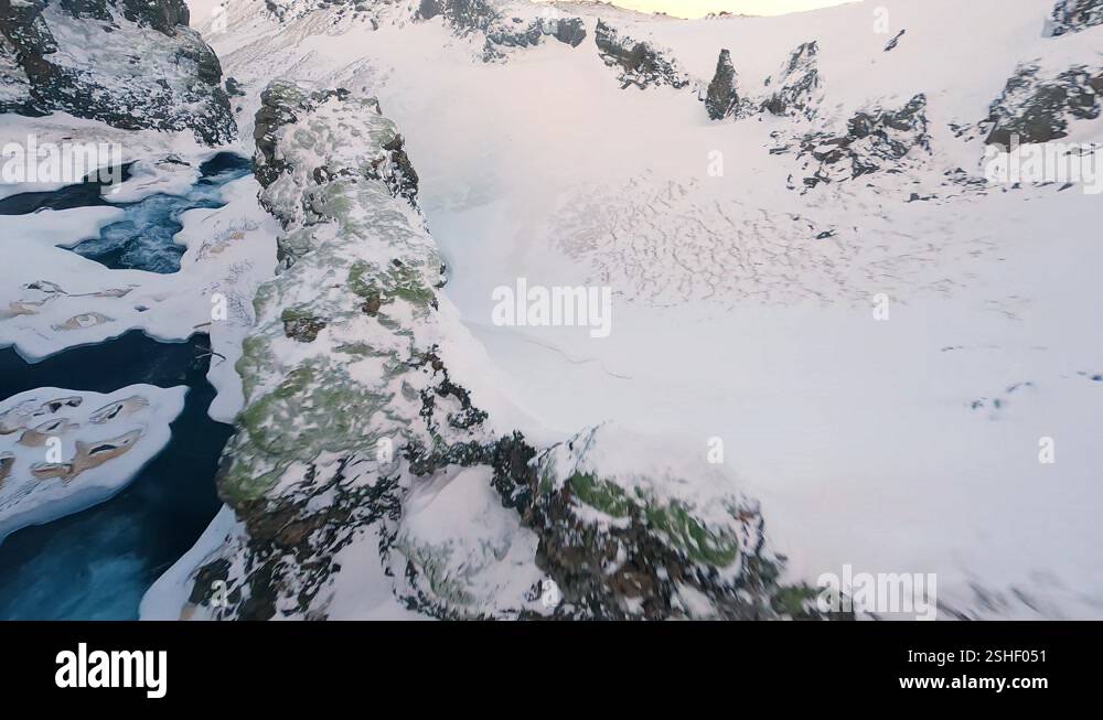 Diving past a flowing waterfall in the wintry highlands of Iceland ...