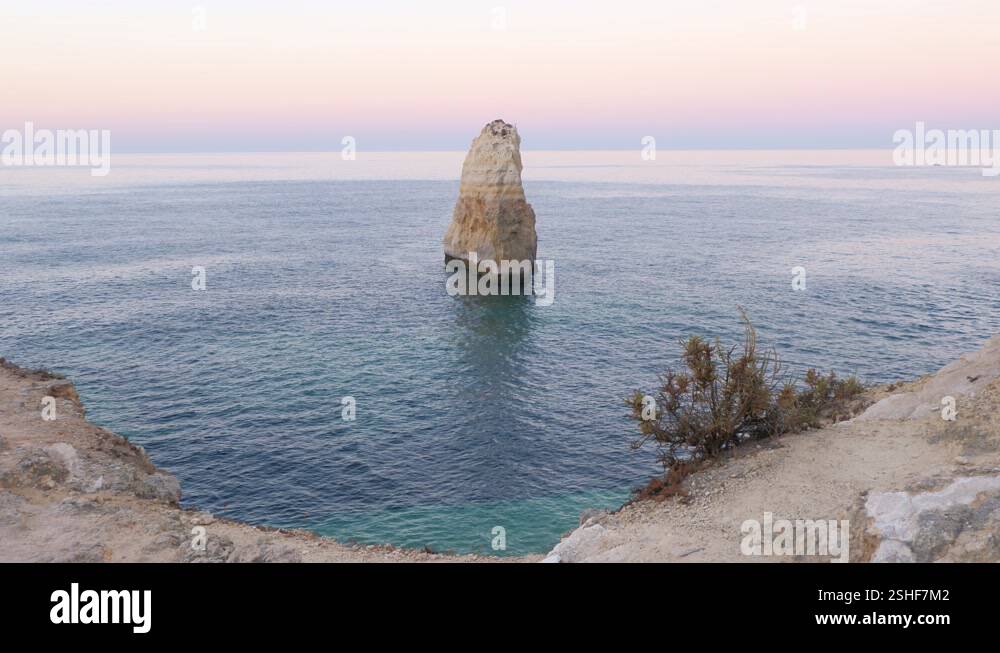 Sunrise clifftop footage of a sea stack pillar on the Algarve coast in ...