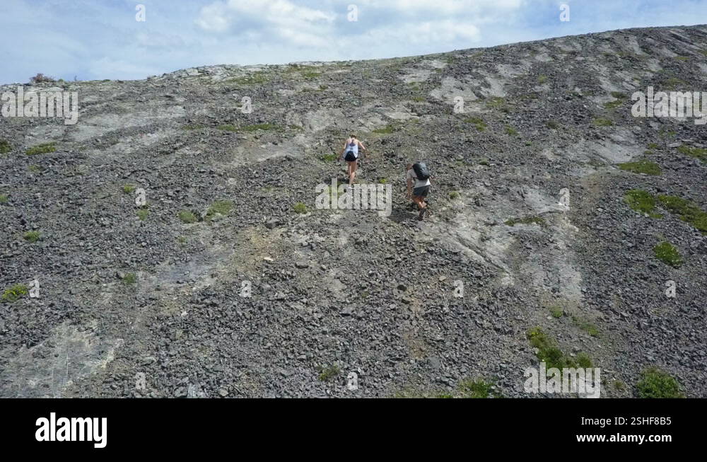 Two hikers climb rough scree slope on Ha Ling Peak in Canadian Rockies ...
