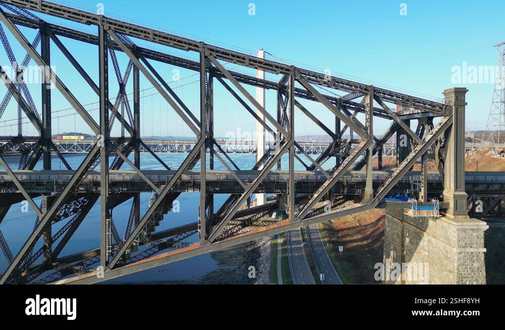 Sideview of two bridges. One old in the front and one more recent in ...