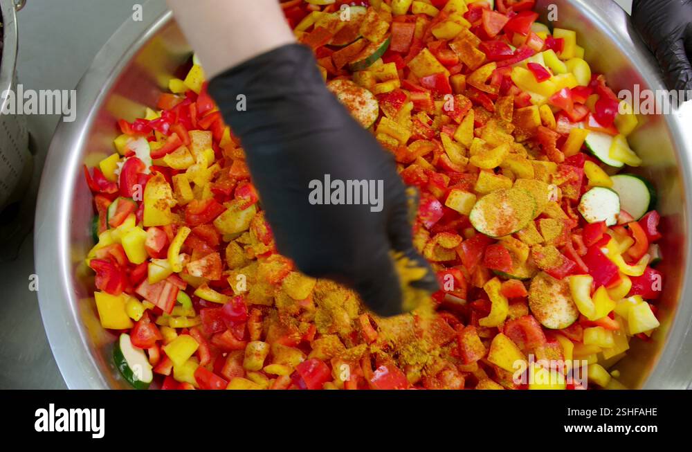 Close-up from above of a chef sprinkling curry spice over chopped Stock ...
