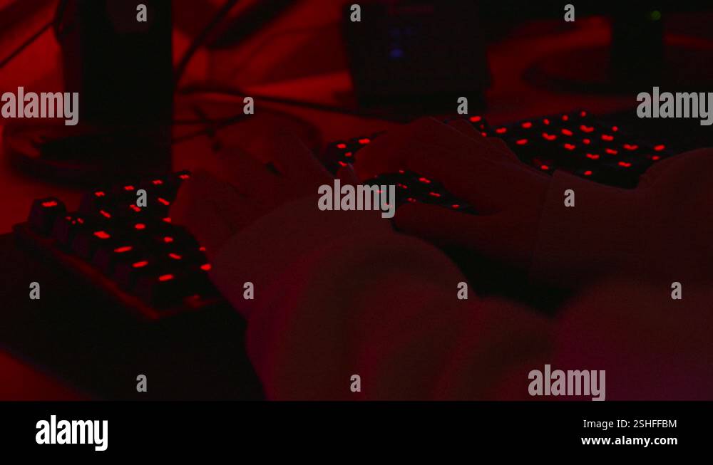 Anonymous hacker in a dark red room typing on red keyboard Stock Video ...