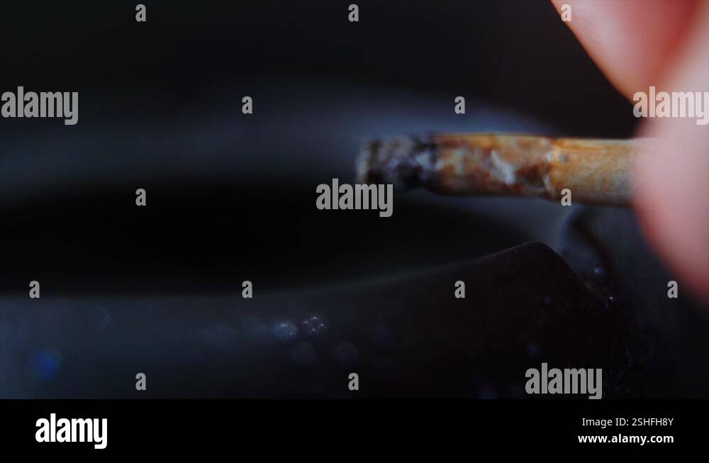 A macro close up shot of ash residue from a cigarette in a black stone ...