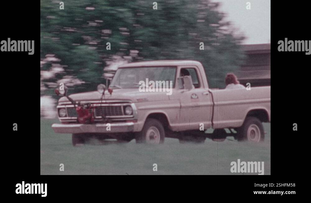 1970s: Pickup truck speeds across farm. Farm buildings and barn under ...