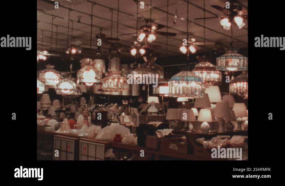 1990s: Lamps and fixtures in a lighting store showroom. The lights turn ...