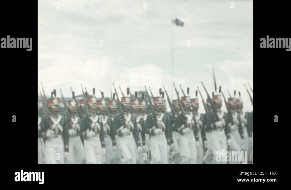 1940s: People stand before monument. People march carrying rifles ...