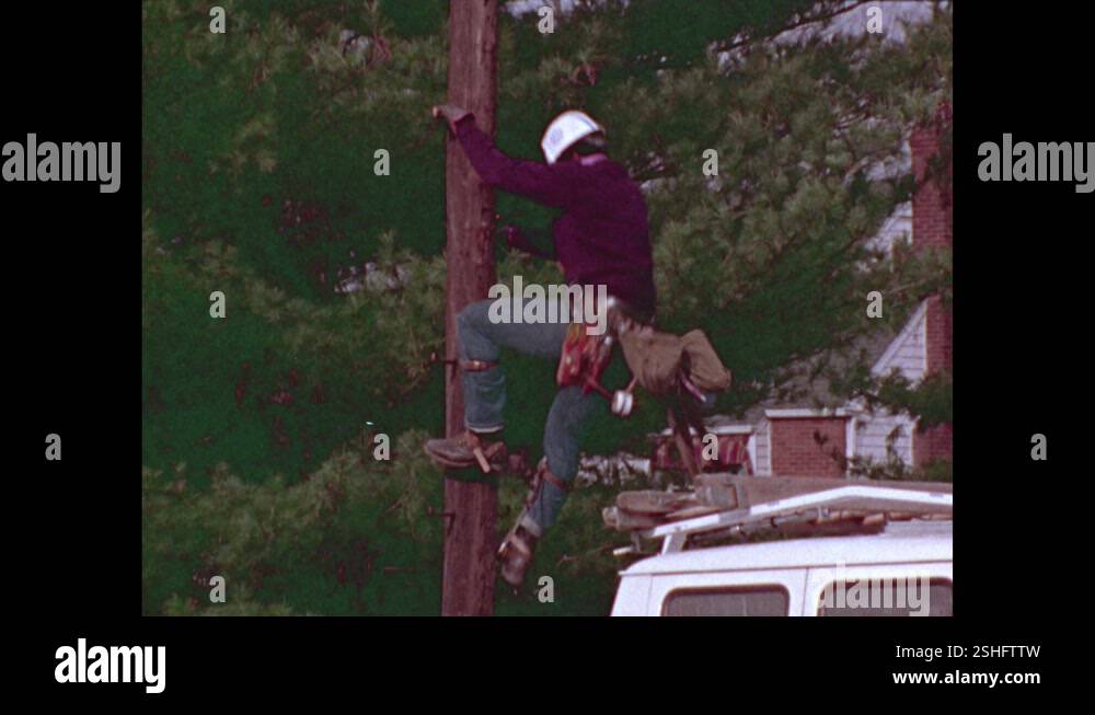 1970s: Lineman climbs down from utility pole. Person picks up telephone ...