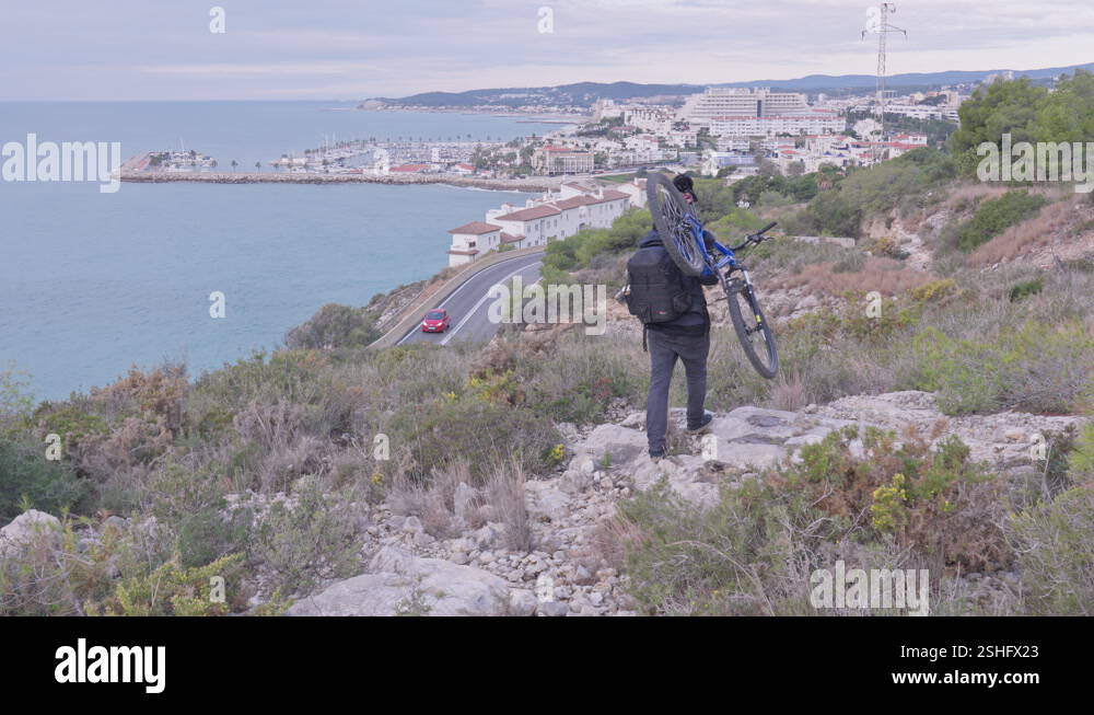 Traveller carries his mountain bike on the sholder as group of cyclists ...