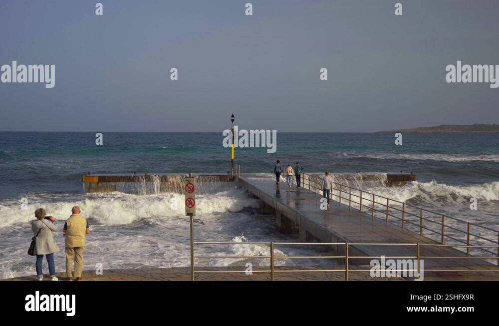 Ocean waves breaking at a stone peer on Mallorca with big splashes an ...