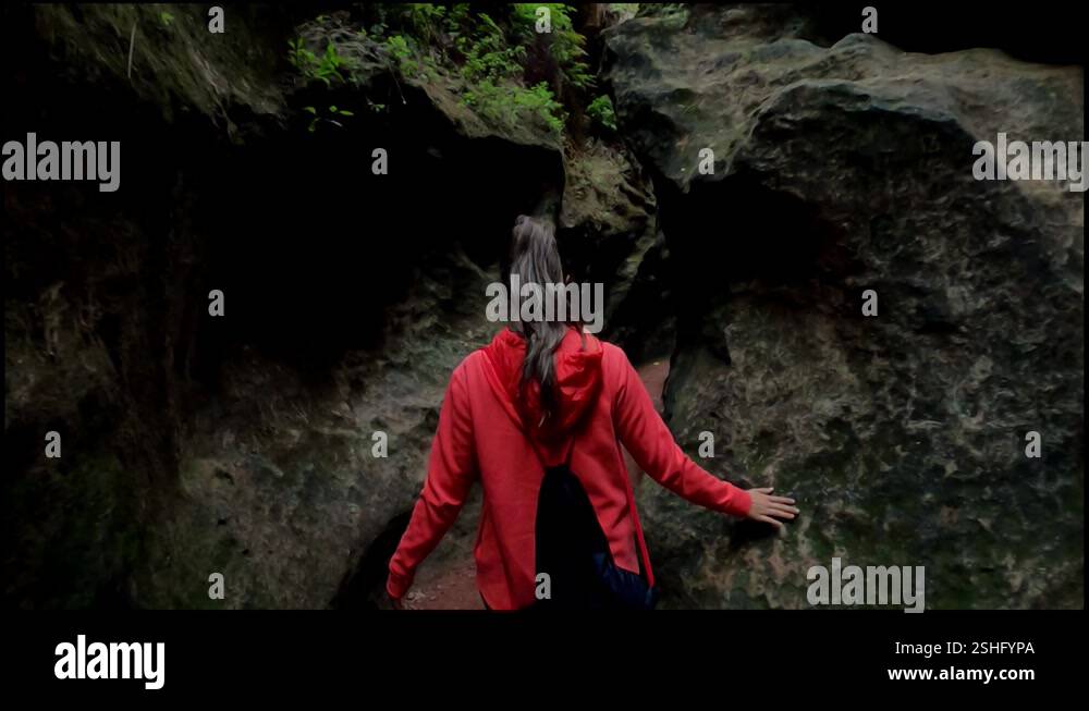 Young explorer walks through a narrow path in caves and caverns in ...