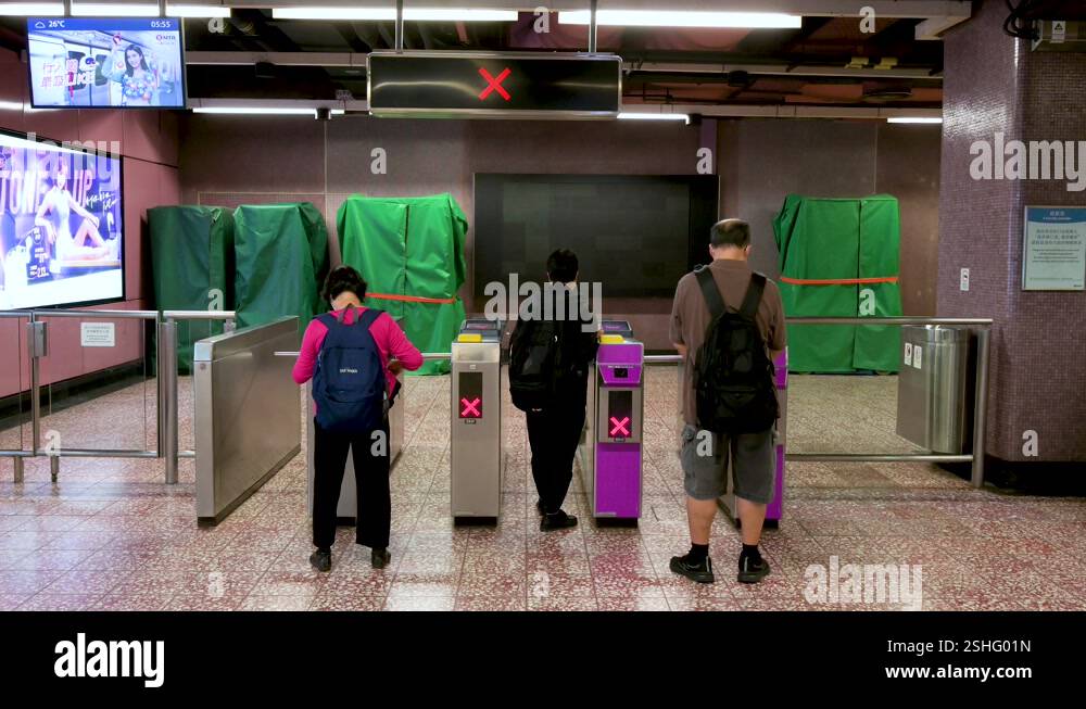 Early morning commuters queue in line as they wait for the MTR subway ...