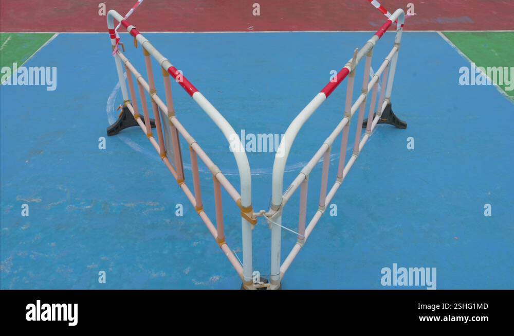 A view of a colorful basketball court blocked by barriers at a closed ...