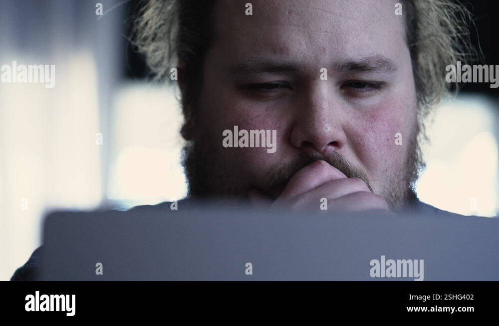 Person staring at screen with skeptical expression reading content ...