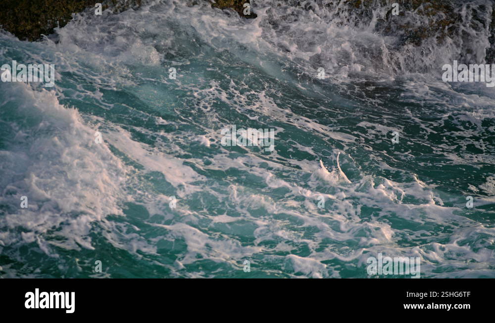 Foamy waves splashing at crag nature close up. Salty sea water crashing ...
