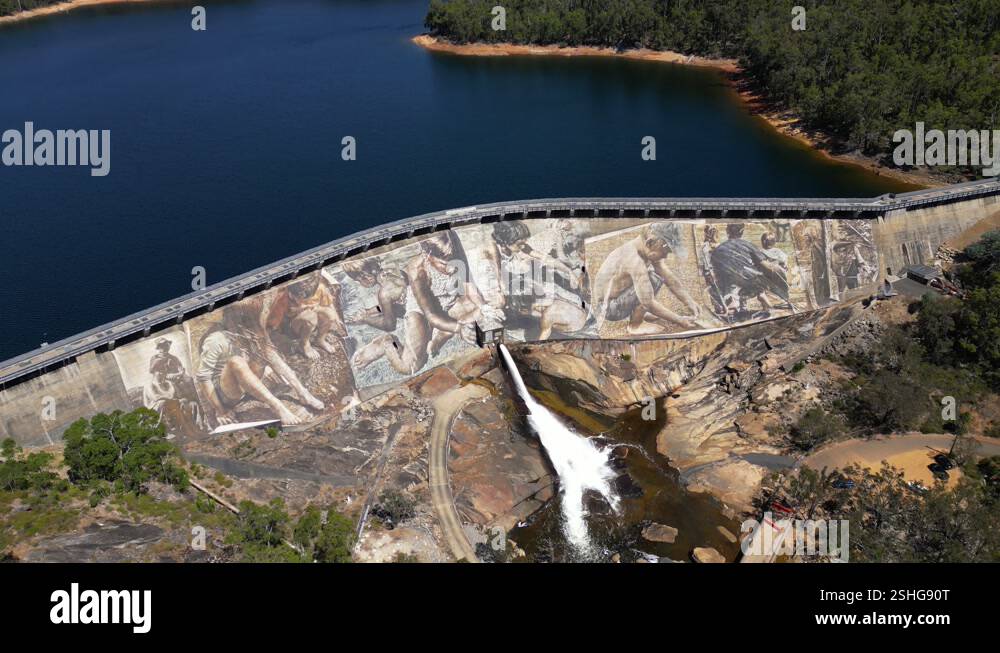 Tilt down aerial of giant panoramic mural painted on active dam in ...