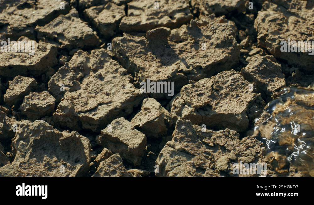 Water streaming through dry cracked soil, water saving land from ...