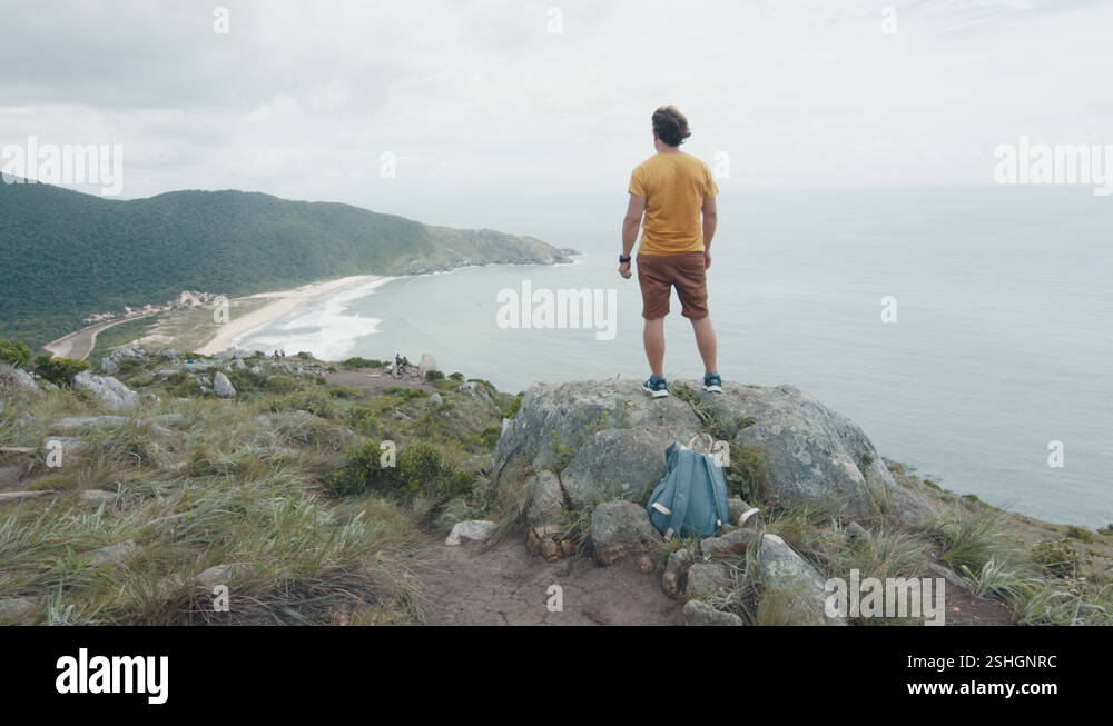 Hiker on the rock. Young man stands on the viewpoint rock and look ...