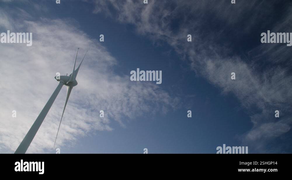 Wind turbine windmill turning in a blue sky with clouds Stock Video ...