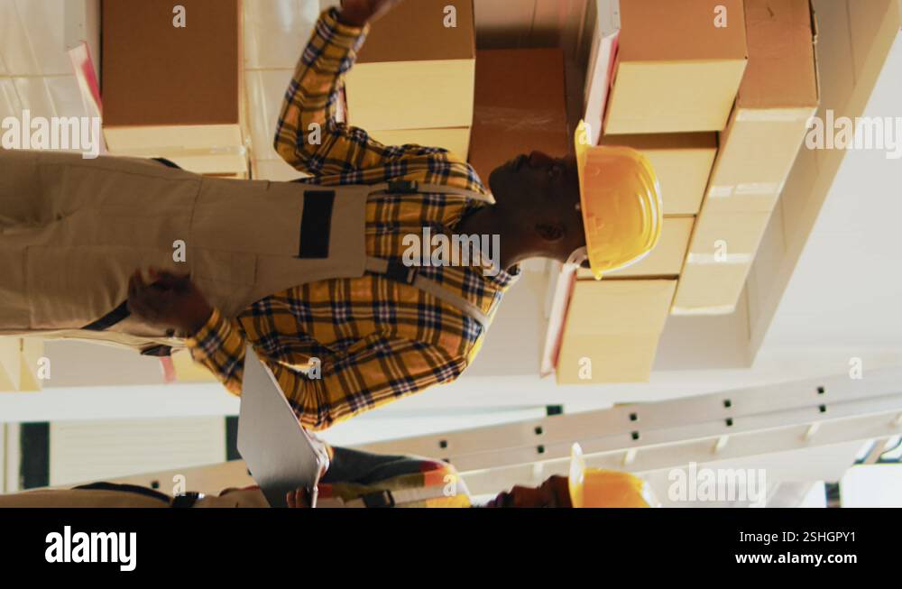 Vertical video: Male employees talking on phone call and writing info ...