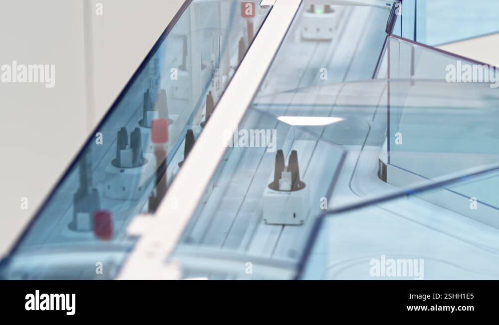 High angle shot of test tubes moving around on an automated lab line ...