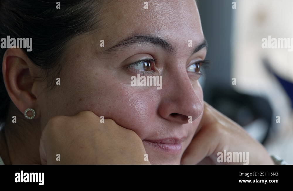 A pensive woman close up face with tearful emotion. Contemplative ...