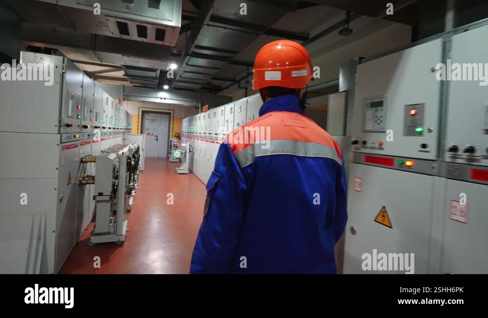 An electrician specialist walking inside the power station, an ...
