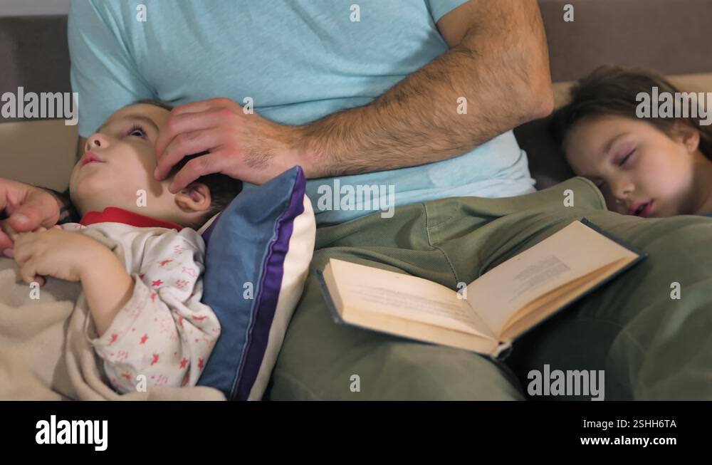 Caring father reading bedtime story to his children at home. Evening ...