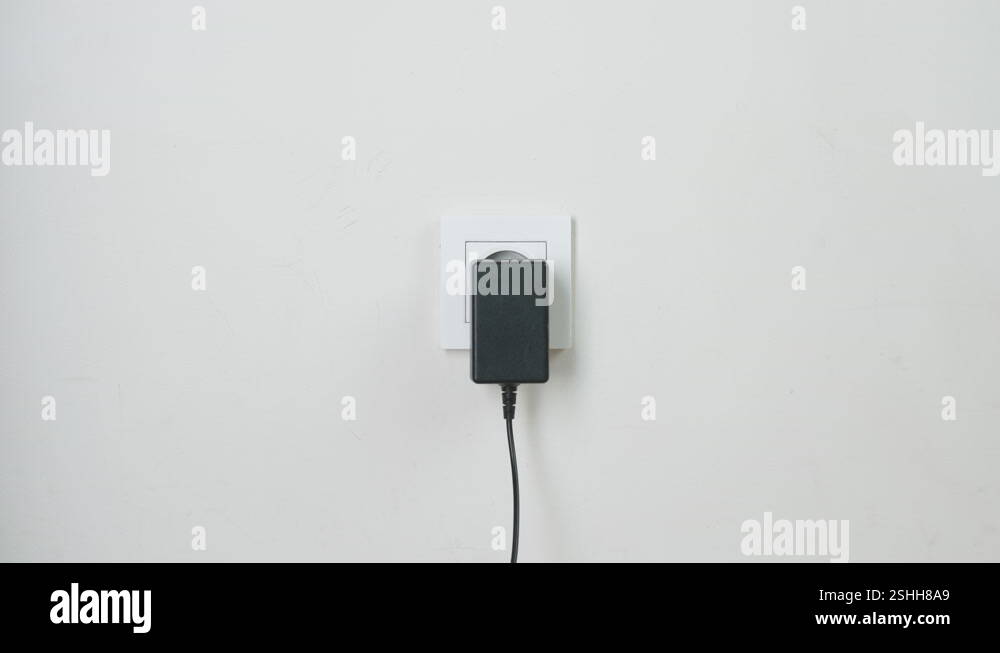 Male hand plugging unplugging charger cable plug into white wall power ...