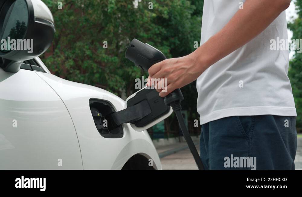 Progressive man install cable plug to his EV car from home charging ...