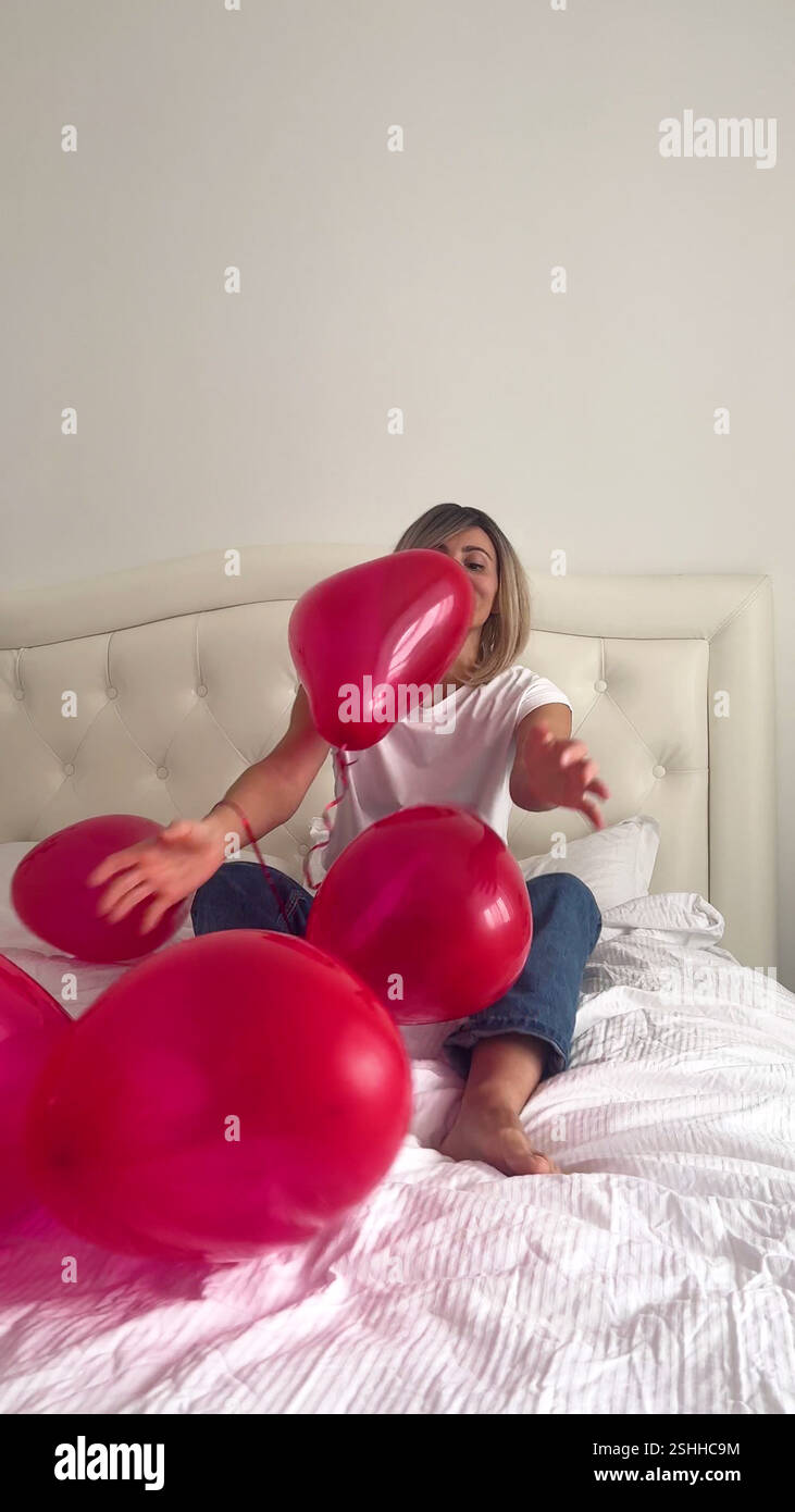 Excited Girl falling on bed with red hearts shape balloons Stock Video ...