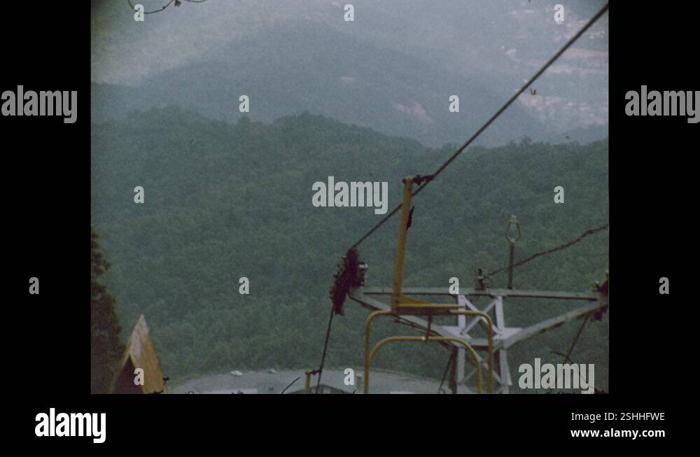 1950s: View riding down from Double Chair lift. Man in funny feathered ...