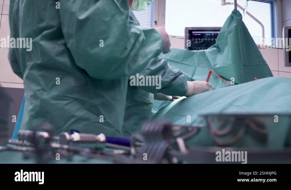 Panning shot of an ongoing surgery. with medical instruments up front ...