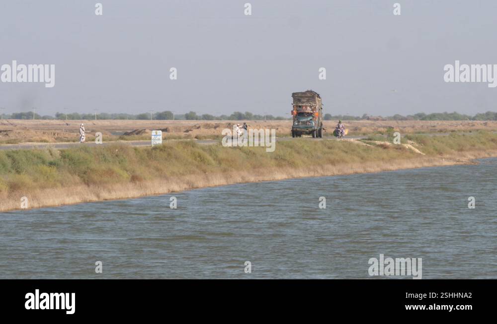 Overloaded Lorry Driving Along Road In Sindh Beside River Approaching ...
