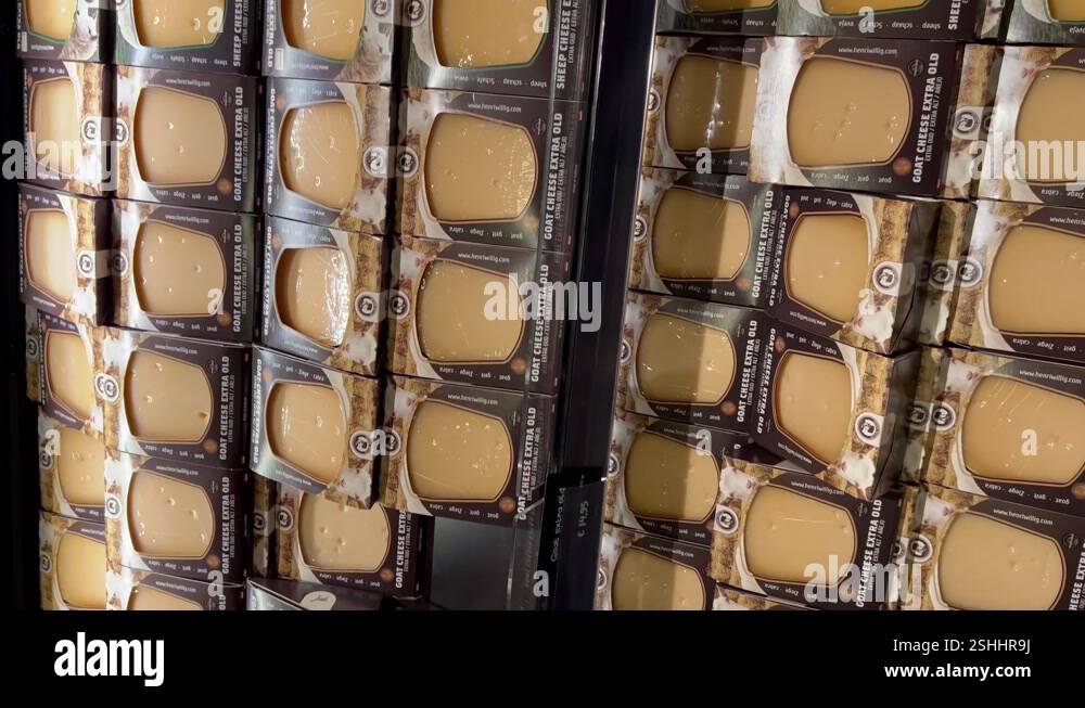Heads of cheese lie on the shelves of a warehouse. Production of Dutch ...