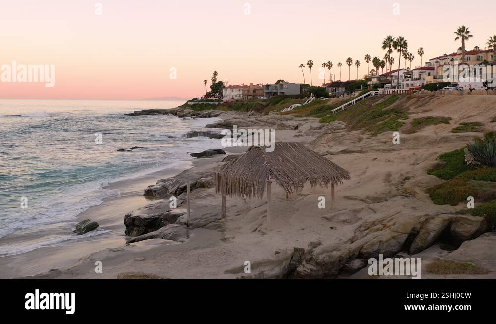Drone flying low backwards over surf shack in La Jolla, California at ...