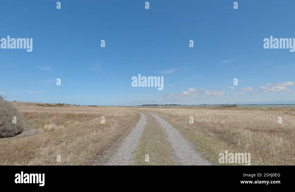 POV off-road cycling on 4WD track as land narrows to meet lake and sand ...