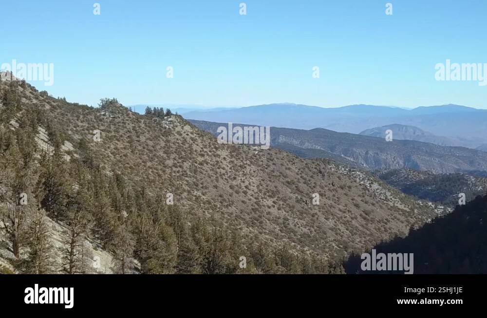 Aerial view of high elevation mountains with blue sky in the background ...