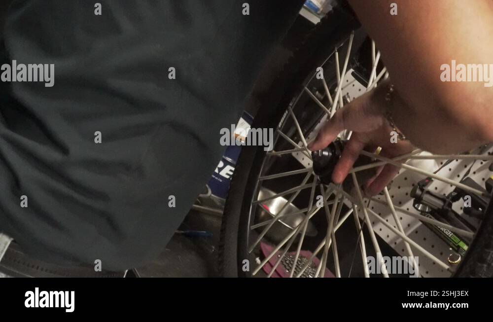 Mechanic cleaning the spokes of the rim of a mountain bike, still shot ...