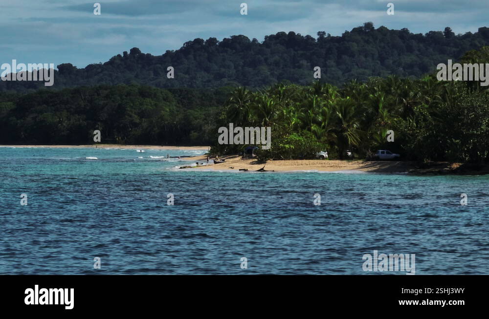 Slide and pan footage of people spending day on narrow stripe of sand ...