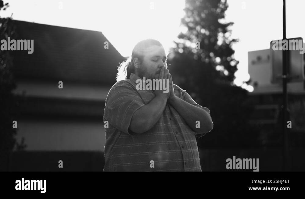 One worried man standing outdoors in black and white. Pensive anxious ...