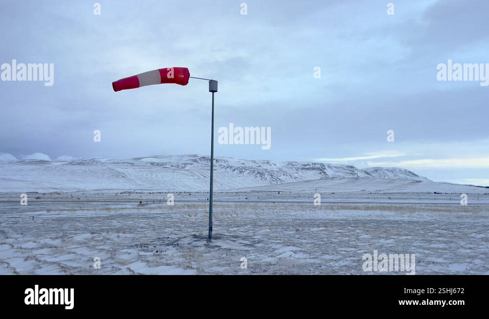 Wind sock moving in the wind on a frozen airport in Iceland with in the ...