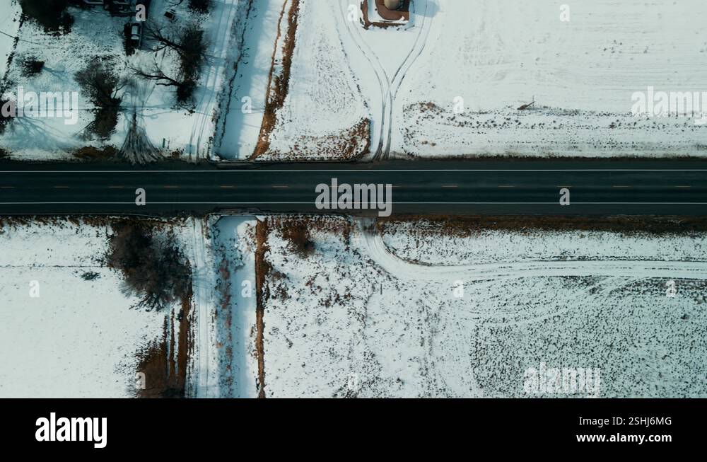 top down on highway in winter. Car enters and leaving the view. Aerial ...