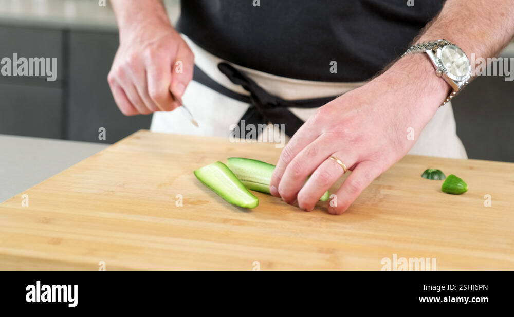 Male model slicing the cucumber with extremely sharp knife on the ...